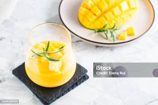 Smoothie Mangga Dalam Gelas Dan Irisan Mangga Di Atas Piring Di Atas Meja Makanan Penutup Buatan
