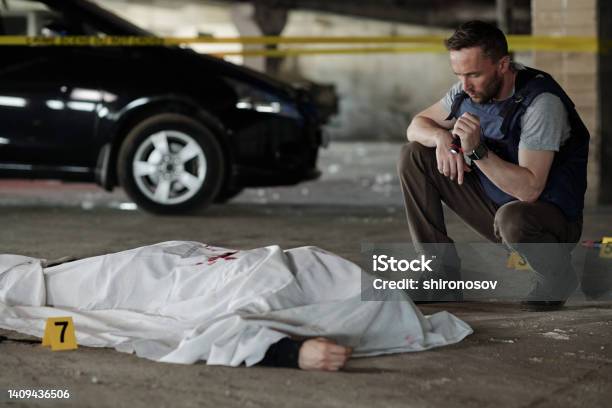 Young Male Detective With Small Lantern Inspecting Crime Scene Area