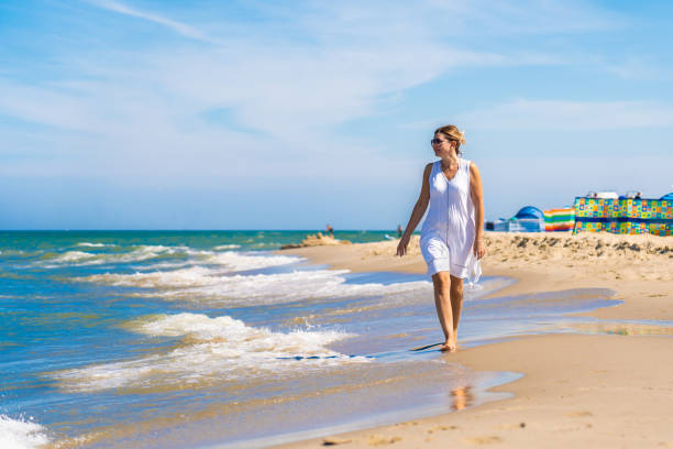 Free Stock Photo of Woman Walking Along Beach by the Ocean | Download ...