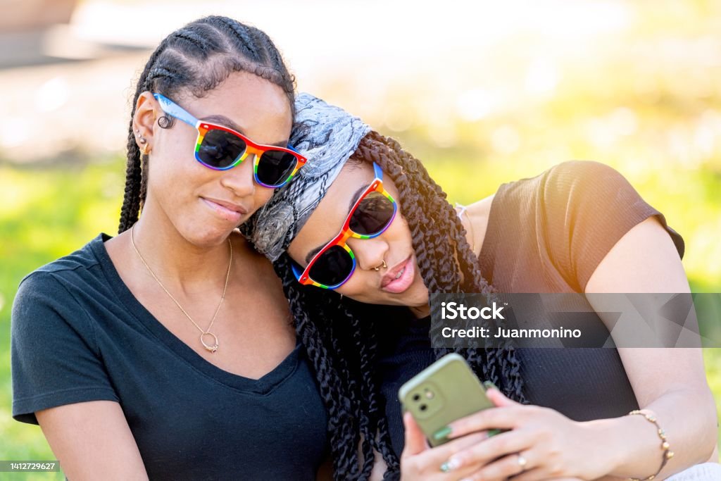 Afrolatinx Playful Young Lesbians Embracing In A Park Taking Selfies