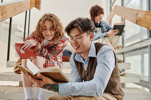 Pasangan Remaja Atau Teman Sekelas Yang Bahagia Membaca Buku Di Tangga ... Pasangan Remaja Atau Teman Sekelas Yang Bahagia Membaca Buku Di Tangga ...