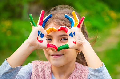 Smiling Girl Making Heart Shape With Colored Finger And Drawing On Palm