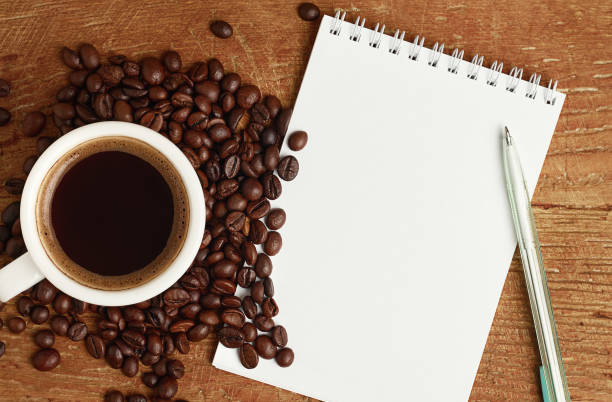 Free Stock Photo of A pile of coffee beans and a spiral notebook ...