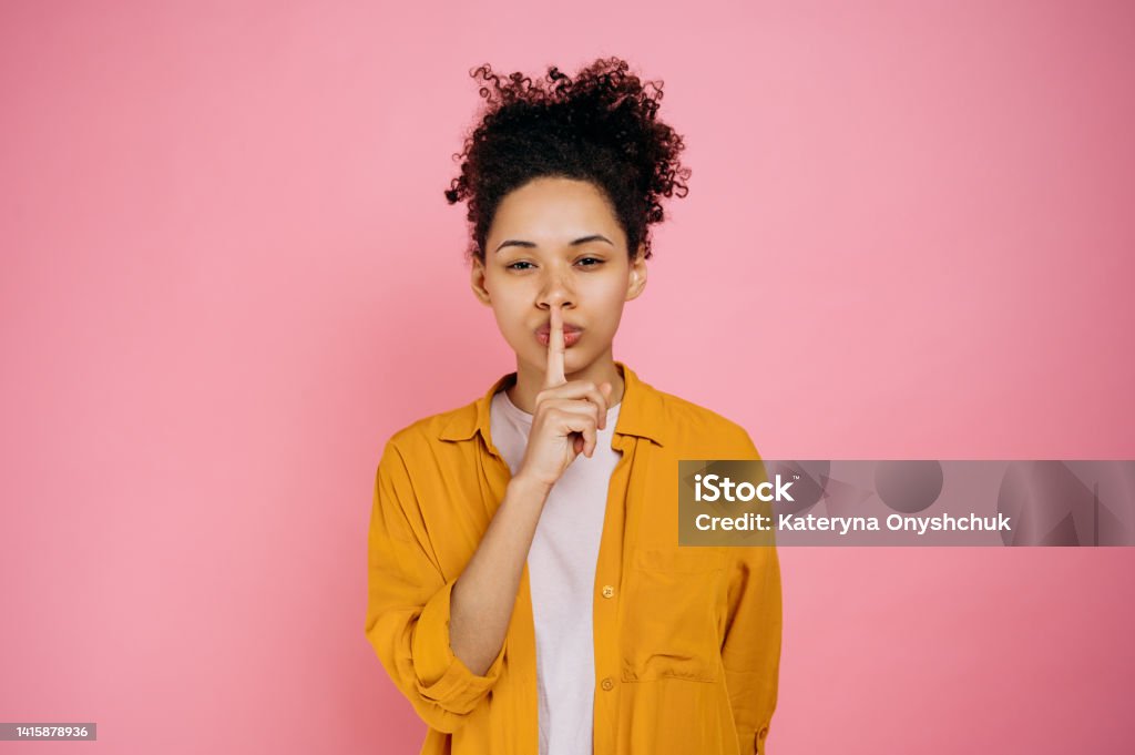 Portrait Of A Pretty Curly Haired African American Girl Showing Shh