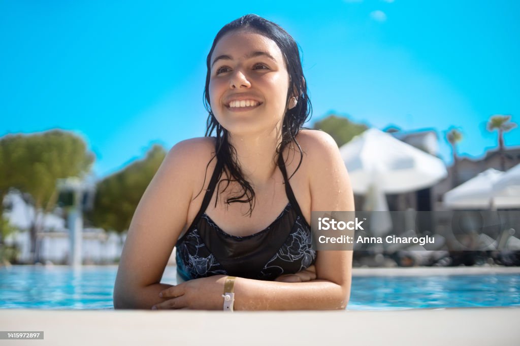Young Brunette Teen Girl Posing In A Blue Swimming Pool In A Hotel In