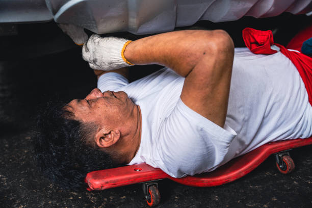 Free Stock Photo of Young female mechanic on a creeper under a car ...