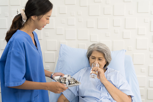 Pasien Lansia Wanita Asia Makan Obat Dan Minum Air Di Tempat Tidur Di