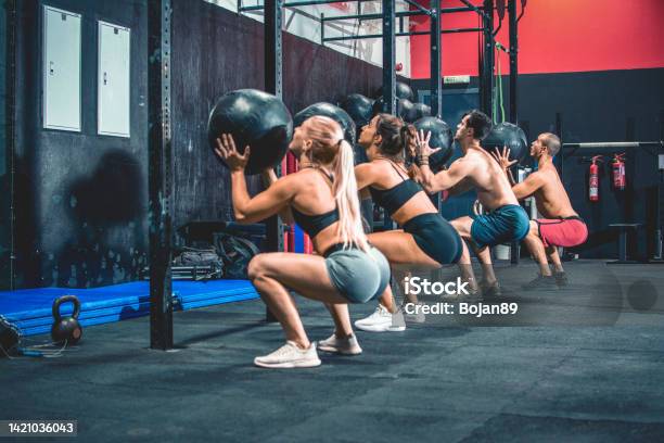 Foto De Grupo De Pessoas Esportivas Fazendo Agachamentos Com Bola