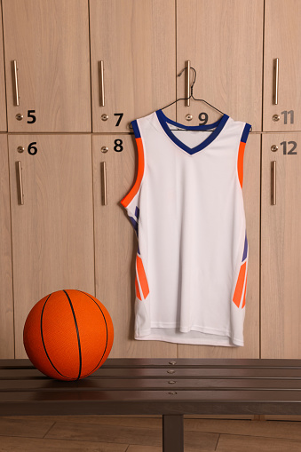 Bola Basket Oranye Di Bangku Kayu Dan Gantungan Dengan Seragam Di Ruang Ganti Foto Stok Unduh