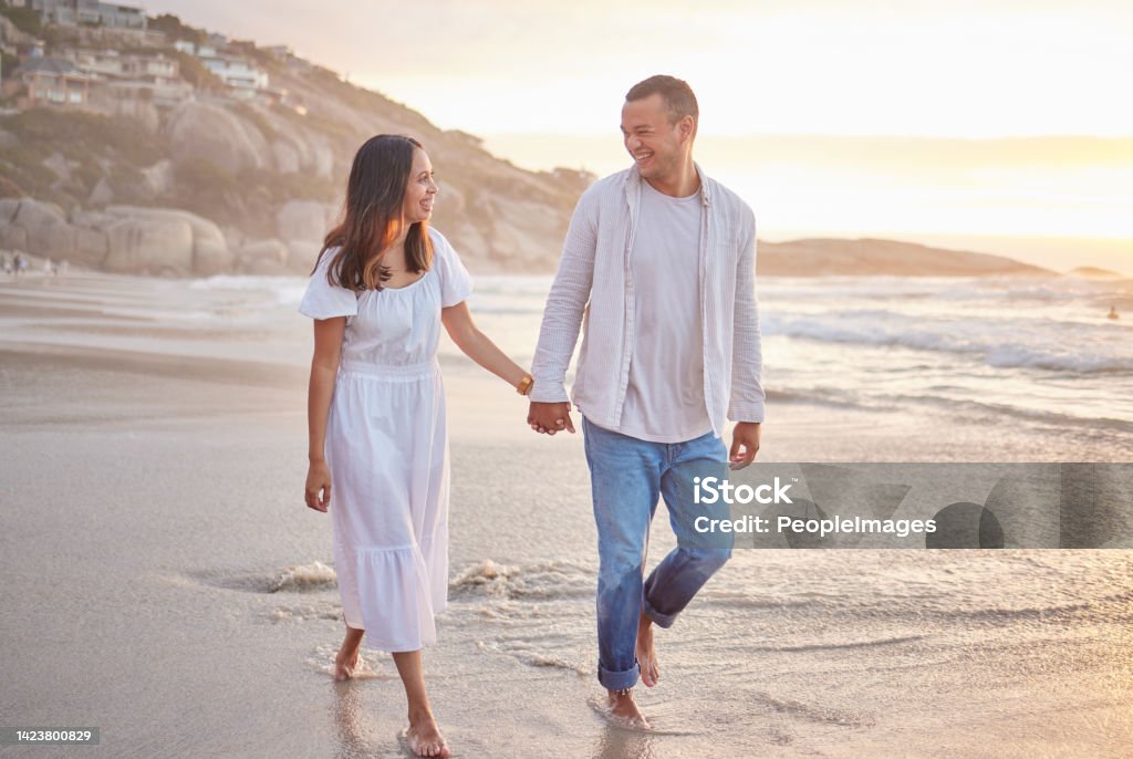 Affectionate Mixed Race Couple Holding Hands And Walking Along The