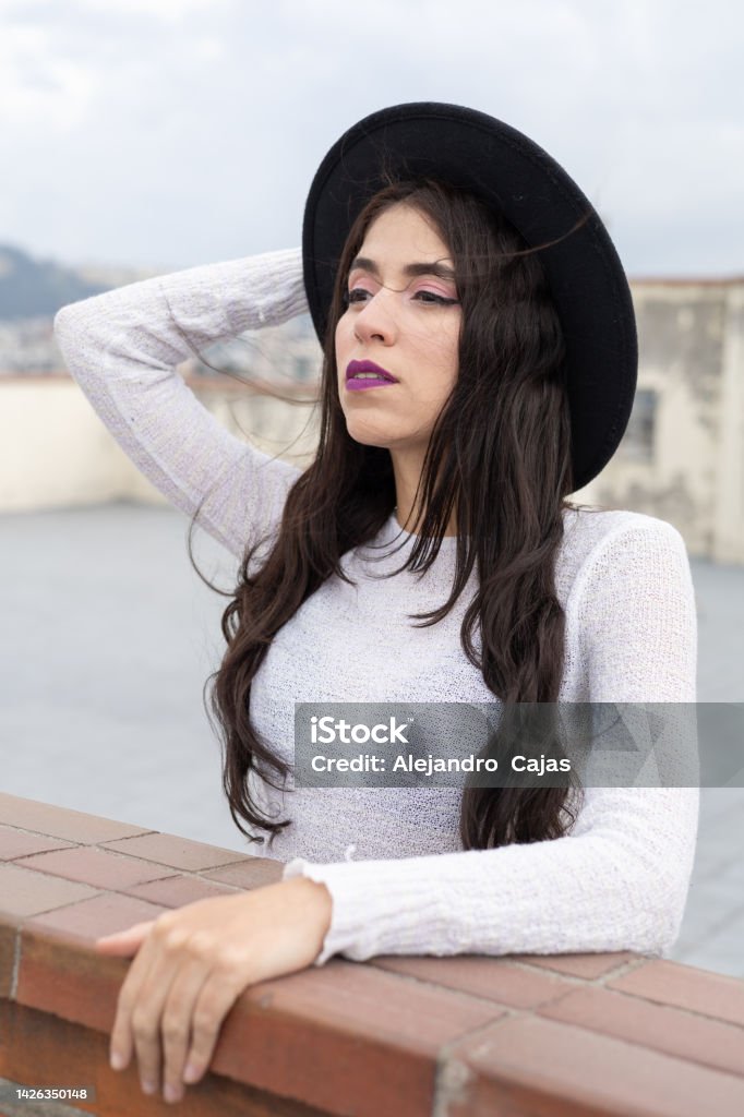Leaning Against A Wall Woman With Natural Makeup Latin Person With Long