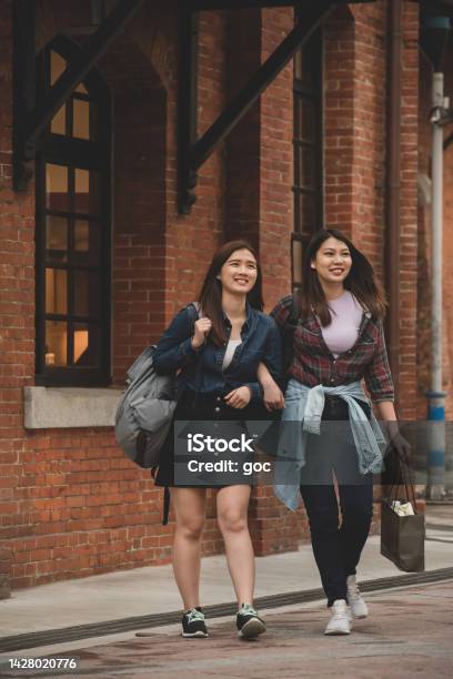 Dua Wanita Asia Yang Gembira Memegang Tas Belanja Dan Berjalan Di Jalan ... Dua Wanita Asia Yang Gembira Memegang Tas Belanja Dan Berjalan Di Jalan ...