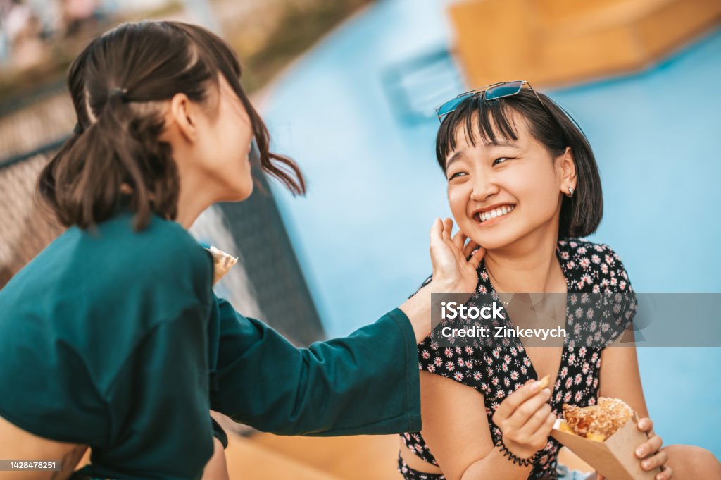 Cute Darkhaired Girl Touching Her Girlfriends Cheek With Tenderness