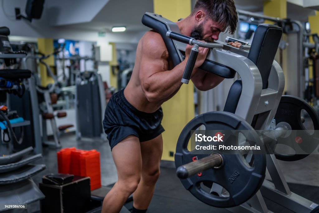 Man Doing Quadriceps Exercise On Hack Squat Machine At Gym Stock Photo ... Man Doing Quadriceps Exercise On Hack Squat Machine At Gym Stock Photo ...
