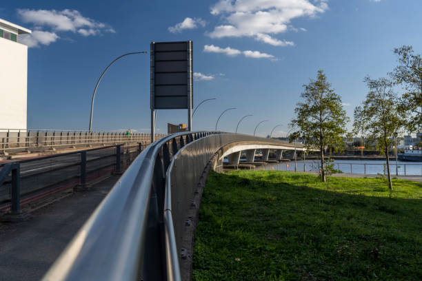 Free Stock Photo of A curved metal pipeline over an urban river ...