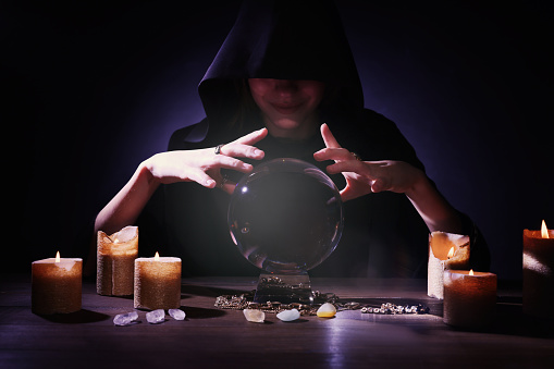 Soothsayer Using Crystal Ball To Predict Future At Table In Darkness