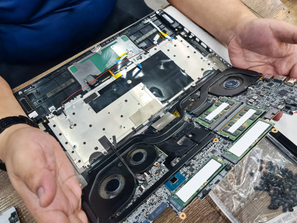 Computer technician disassembling mainboard with circuit of laptop ...