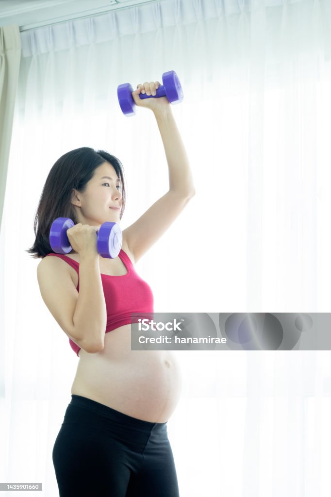Beautiful Pregnant Woman Do Exercise Standing And Lifting Dumbbells