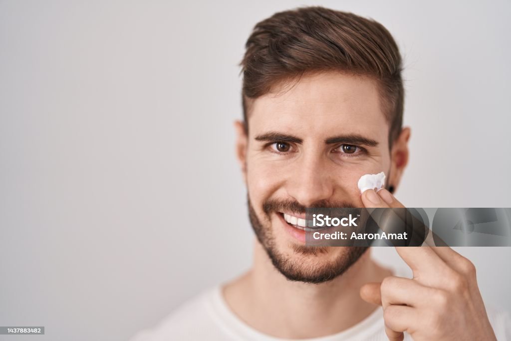 Hispanic Man With Beard Using Moisturizer Facial Cream Smiling And