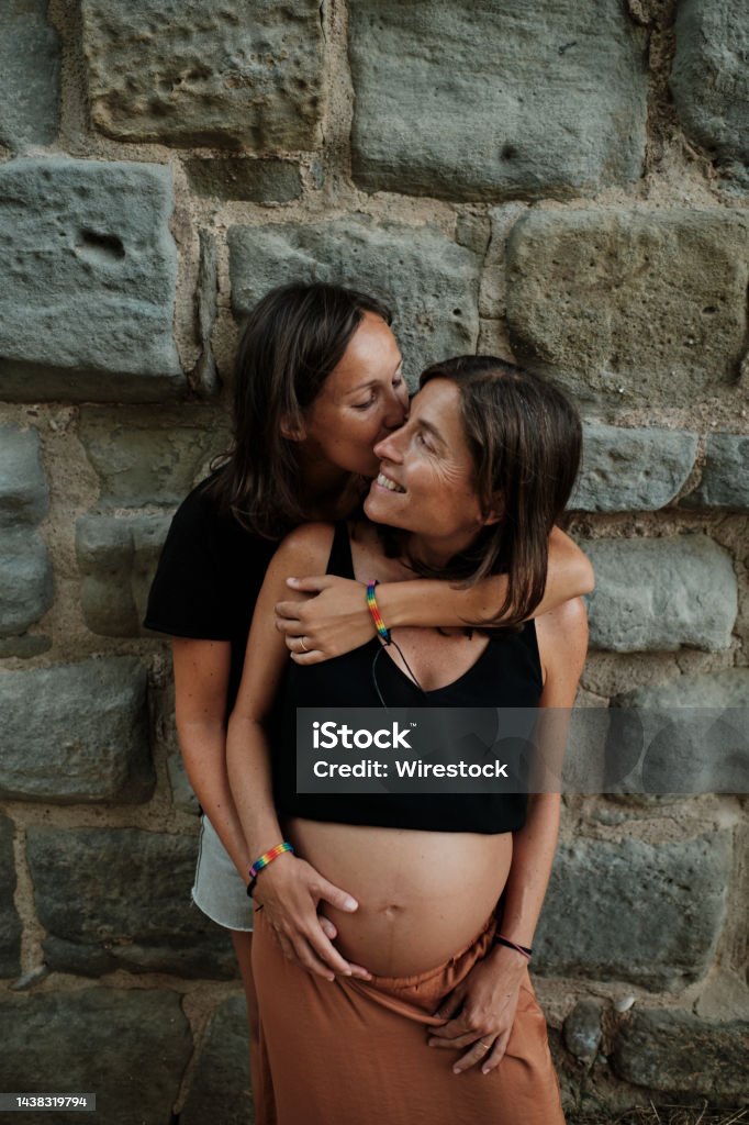 Vertical Closeup Of A Pregnant Lesbian Couple Doing A Photoshoot In A