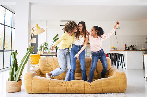 Tiga Teman Wanita Lucu Menari Berdiri Di Sofa Di Dalam Ruangan Wanita ... Tiga Teman Wanita Lucu Menari Berdiri Di Sofa Di Dalam Ruangan Wanita ...