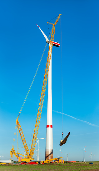 Construction Work Of Wind Turbine Crane Is Holding Grabing A Blade Of A Wind Turbine Building