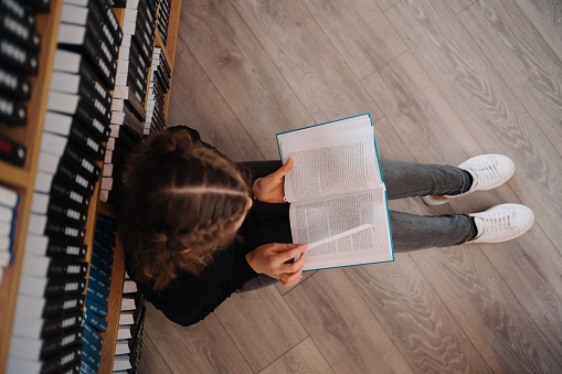 Gadis Cantik Sedang Belajar Membaca Buku Sambil Duduk Di Lantai Di