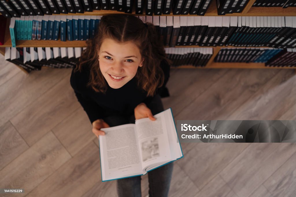 Gadis Cantik Sedang Belajar Membaca Buku Sambil Duduk Di Lantai Di