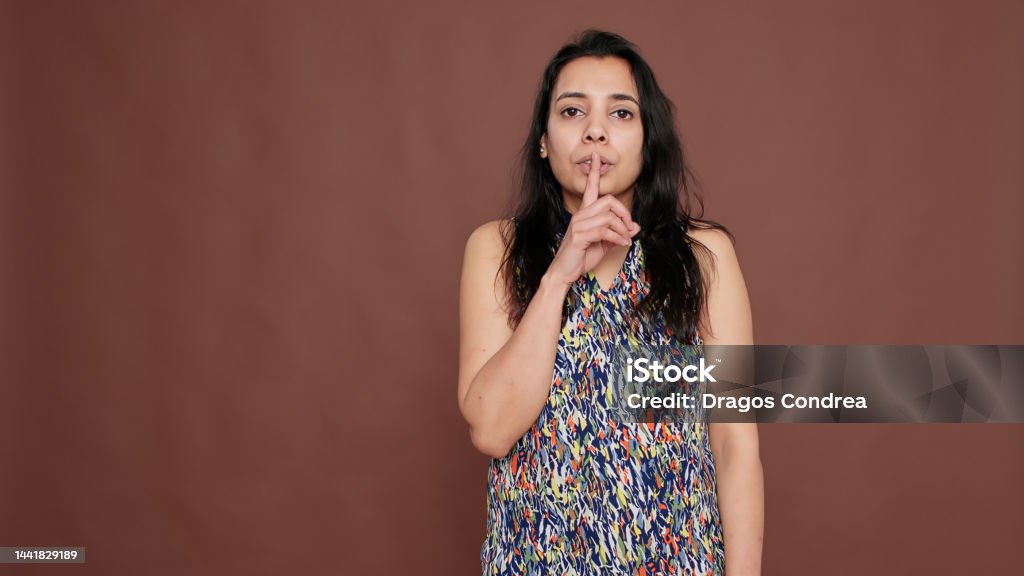 Indian Person Making Hush Gesture With Index Finger Over Lips Stock