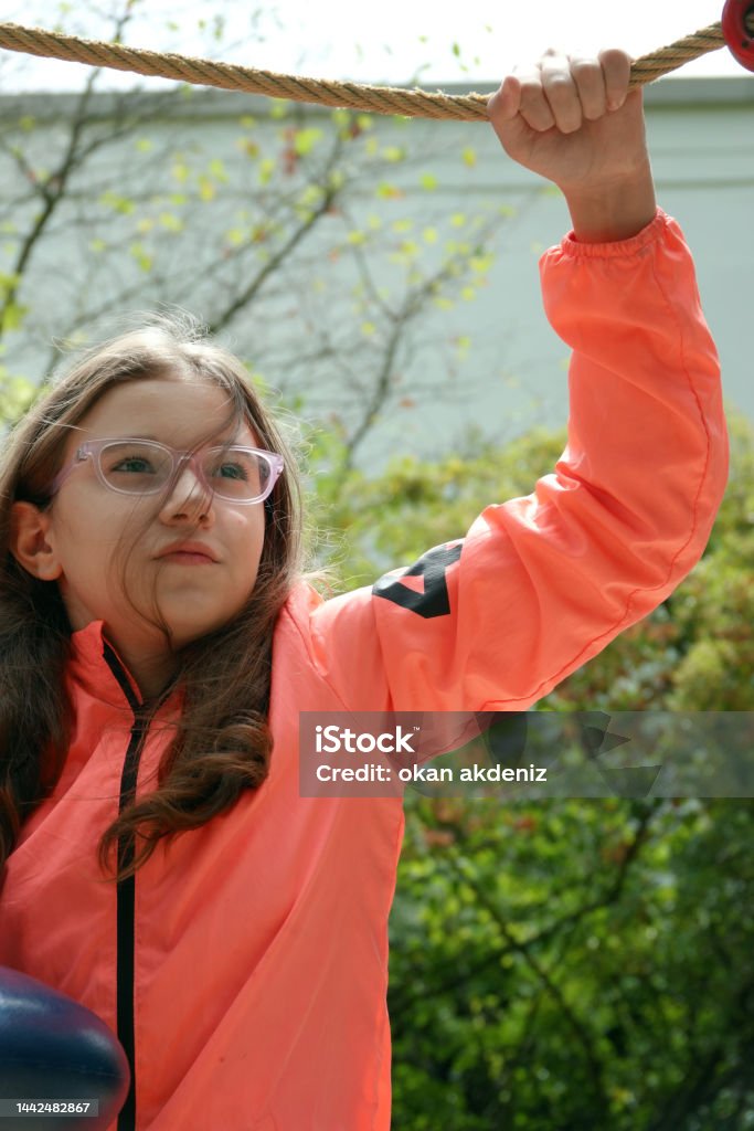 Teenage Girl Is Holding Ropes For Climbing In The Playground Stock