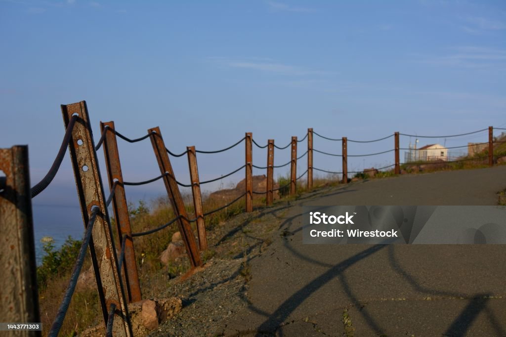 나무와 밧줄 울타리가 있는 시골 지역의 가장자리와 아래에서 보이는 호수의 전망 0명에 대한 스톡 사진 및 기타 이미지 0명