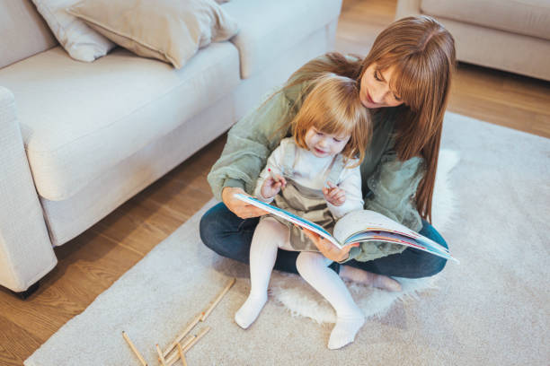 Free Stock Photo of Mother on the floor reading book with her child ...