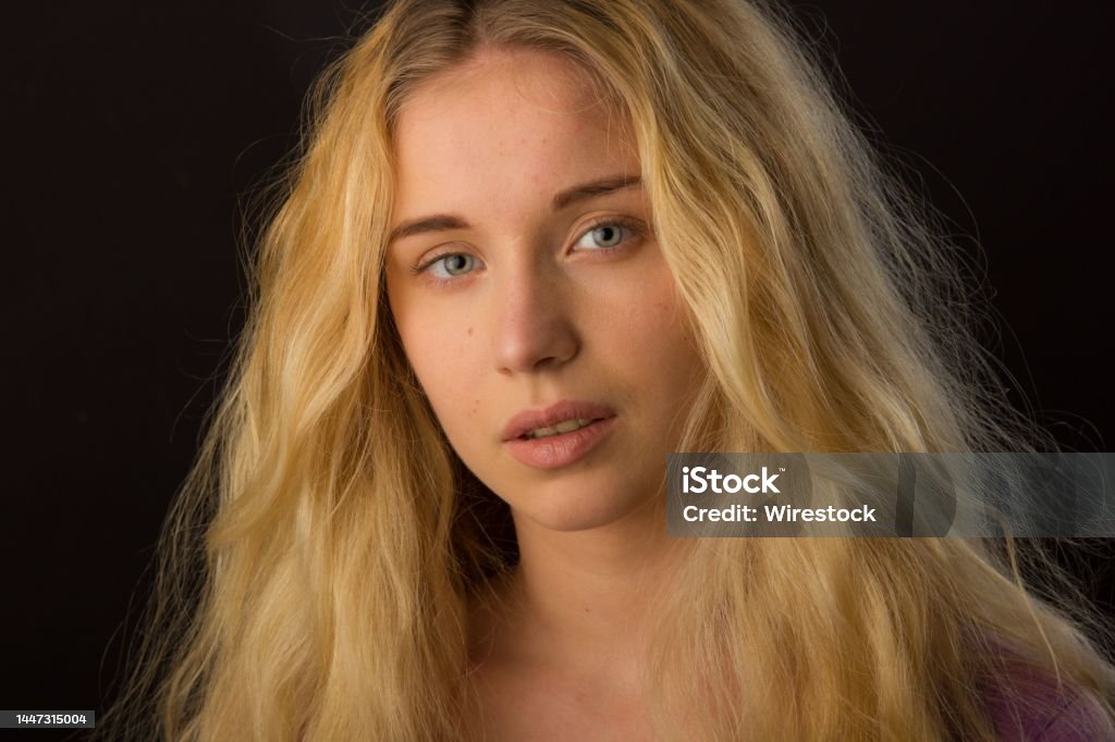 Closeup Portrait Of A Caucasian Blonde Woman Standing In Front Of A