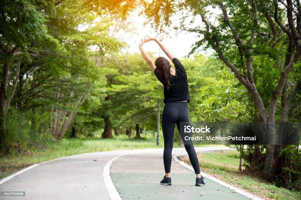 Asian Woman Stretching Before Start Running Exercise In Outdoor City