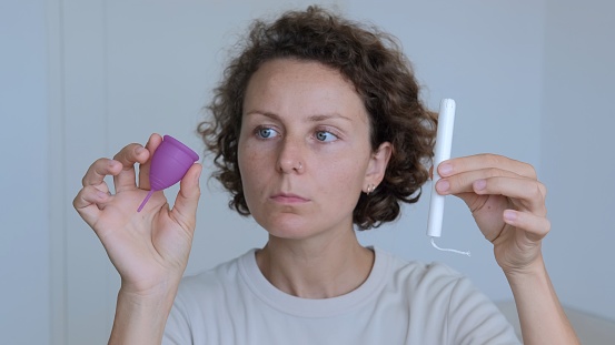 Seorang Wanita Memegang Tampon Dan Cangkir Menstruasi Di Tangannya ... Seorang Wanita Memegang Tampon Dan Cangkir Menstruasi Di Tangannya ...