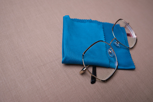 Woman Cleans Her Glasses With A Cloth Wipes Eyeglass Lenses Closeup Of A Womans Hand With