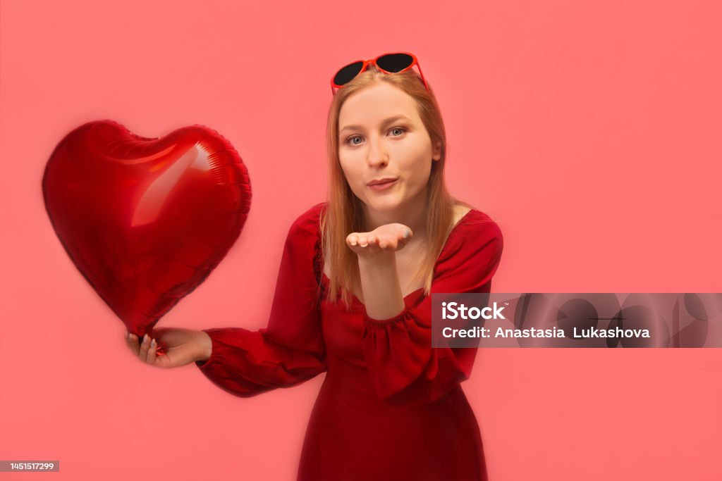 Cheerful Blonde Girl Sending Air Kiss With Pout Lips Palm Holding Red