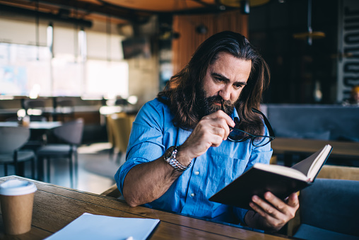 Concentrated Handsome Bearded Male Reader Holding Interesting