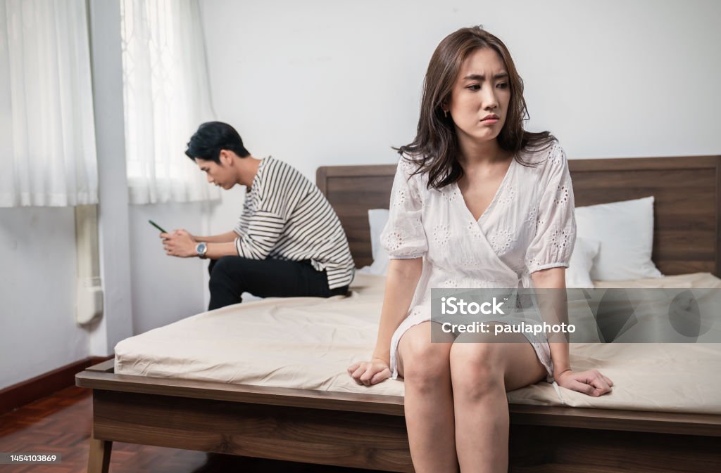 Portrait Of Depressed Man Woman Sitting In Bedroom Young Couple Having