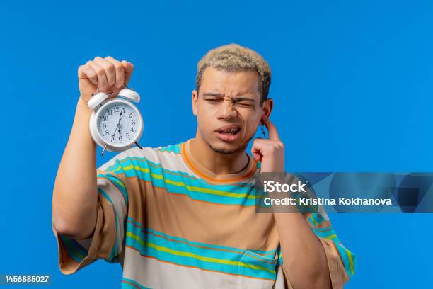 Woken Up By Alarm Clock Sleepy Man Holding It In Hand Blue Background