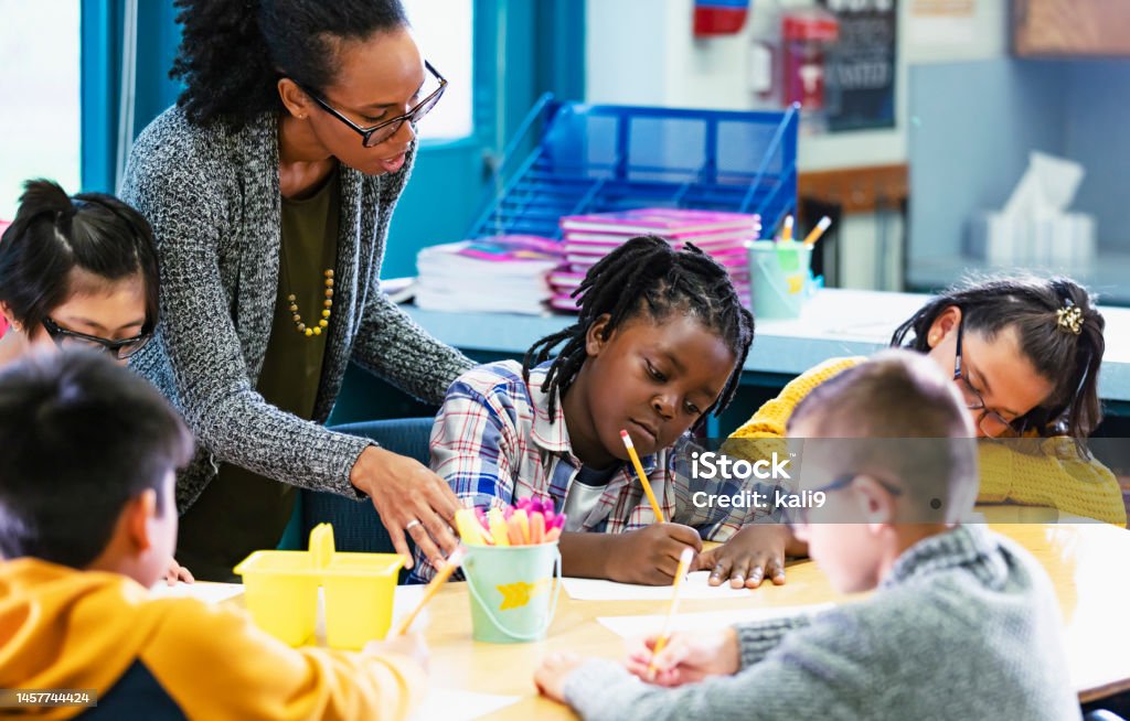 Teacher Helping Elementary Students Writing In Class Stock Photo ... Teacher Helping Elementary Students Writing In Class Stock Photo ...