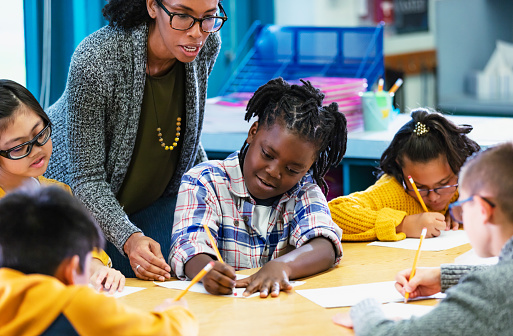 Teacher Helping Elementary Students Writing In Class Stock Photo ... Teacher Helping Elementary Students Writing In Class Stock Photo ...