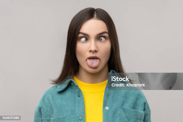 Woman Sticking Out Tongue And Looking At Camera With Crossed Eyes