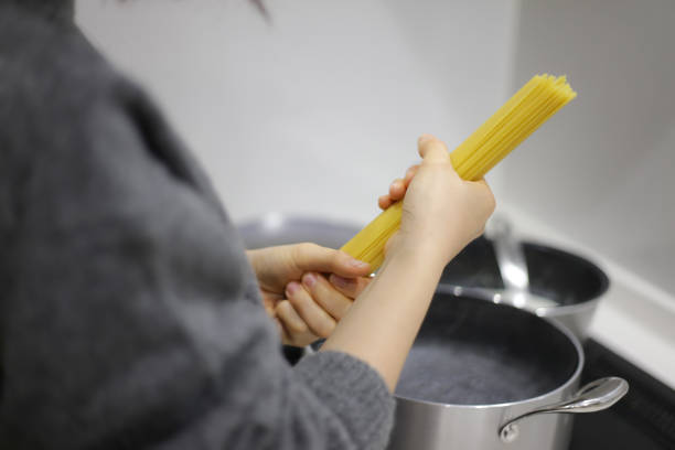 Free Stock Photo of Person Holding Bunch of Spaghetti Over Stove ...