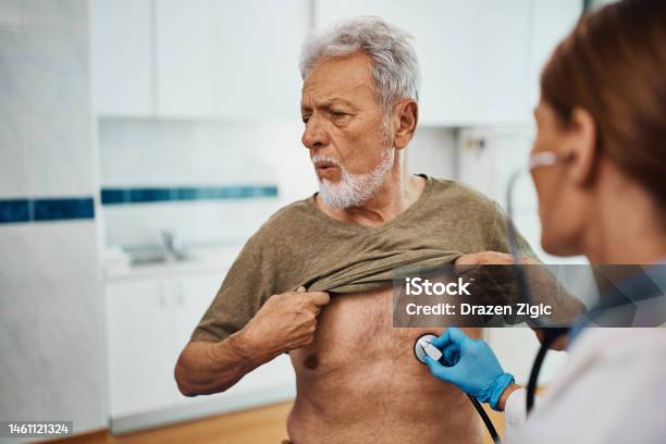 Pria Senior Batuk Saat Dokter Memeriksa Paruparunya Dengan Stetoskop Di ... Pria Senior Batuk Saat Dokter Memeriksa Paruparunya Dengan Stetoskop Di ...