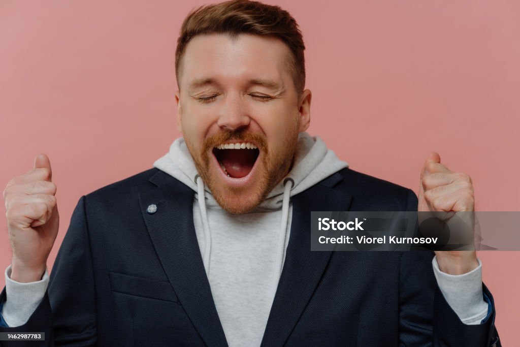 Overjoyed Man With Clenched Fists And Closed Eyes Celebrating Victory