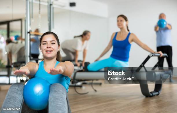 Class Of People Of Different Ages Holding Balls Between Legs And