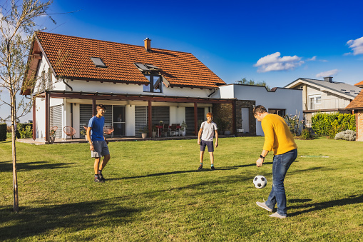 Family Father Is Playing Soccer With His Two Sons Trying A Trick With ... Family Father Is Playing Soccer With His Two Sons Trying A Trick With ...