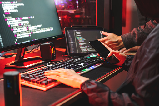 Dangerous Hooded Hacker Typing Bad Data Into Computer Online System And
