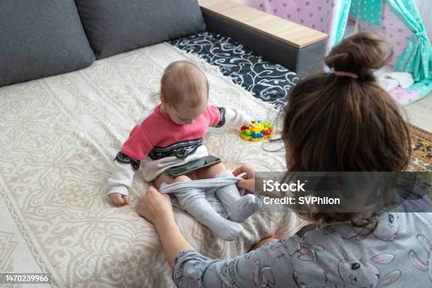 Die Mutter Zieht Ihrer Tochter Morgens Die Strumpfhose Der Kinder An ... Die Mutter Zieht Ihrer Tochter Morgens Die Strumpfhose Der Kinder An ...